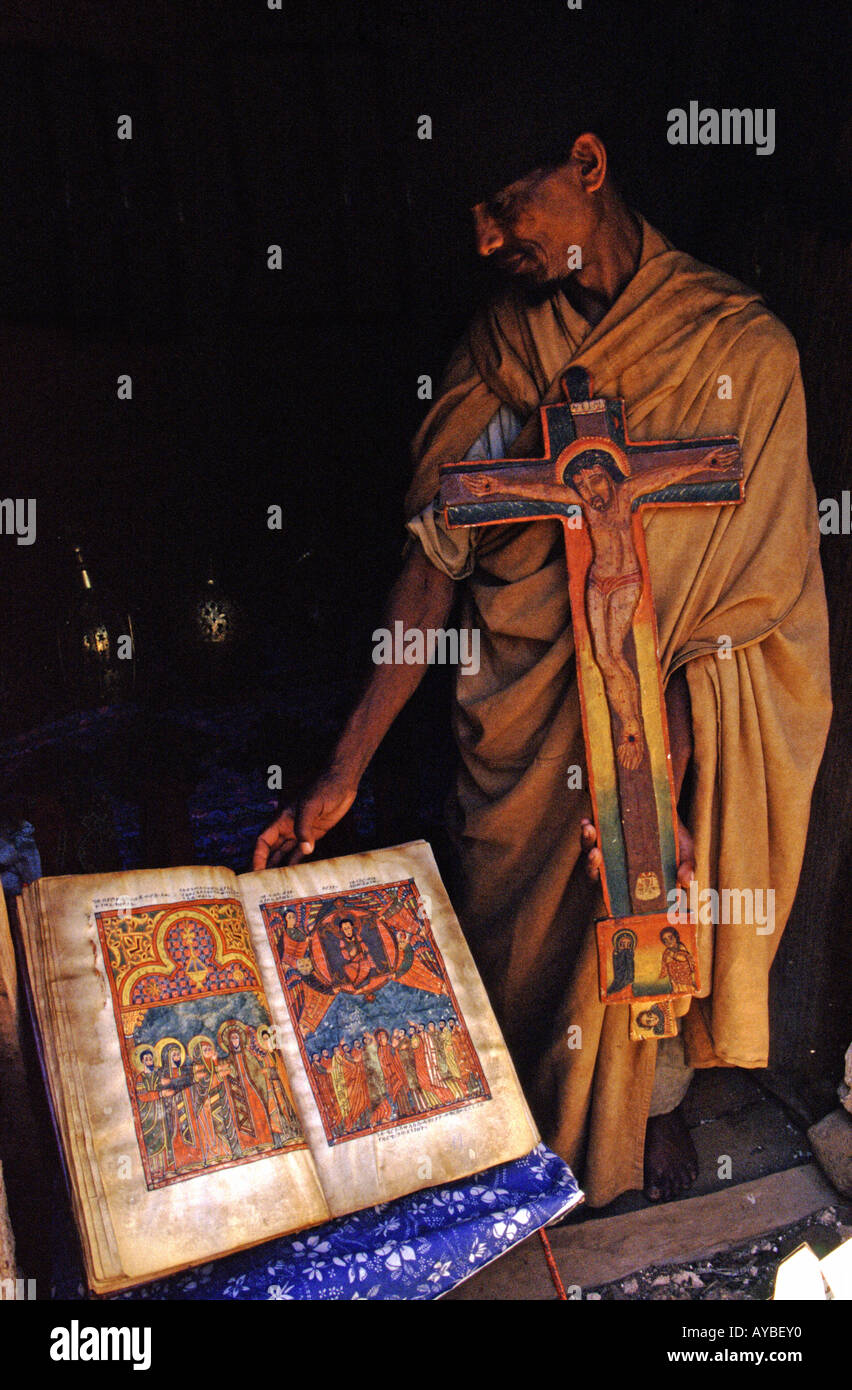 Monk with painted cross and ancient illustrated bible in a monastery on ...