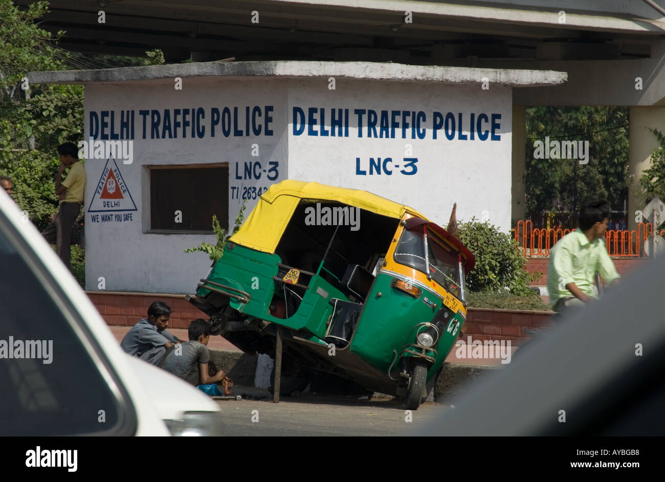 Broken down yellow and green tuk tuk taxi, outside the Delhi Traffic ...