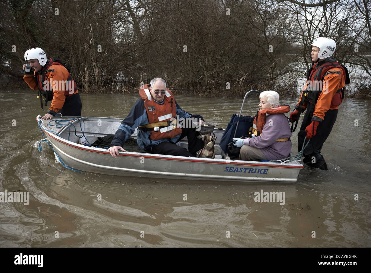 Rescue workers ferrying passengers in a boat from flood water Stock ...