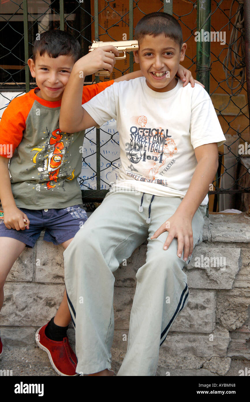 Boy pointing gold toy gun at his own head. Zeyrek, Istanbul, Turkey ...
