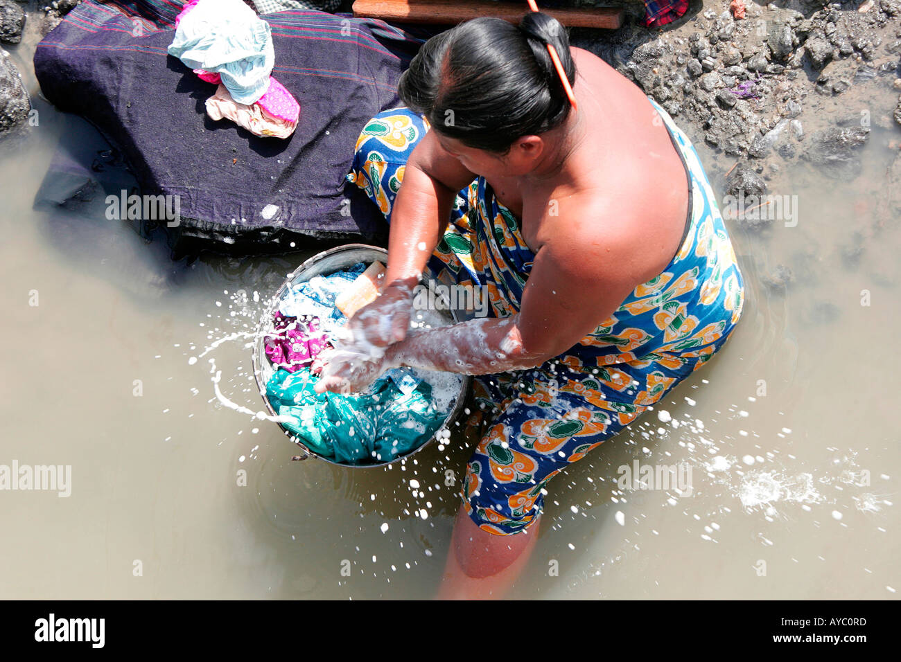 Burmese woman washing clothes on the banks of the Irrawaddy River near ...