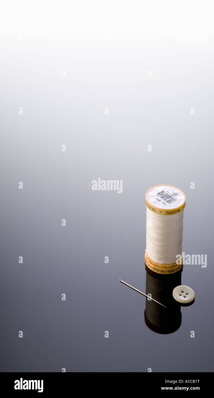 Bobbin white cotton button and needle Stock Photo - Alamy