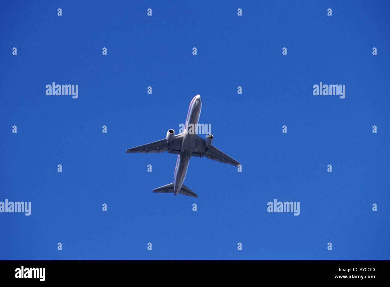 Looking up at a commercial jet aircraft taking off against a perfect ...