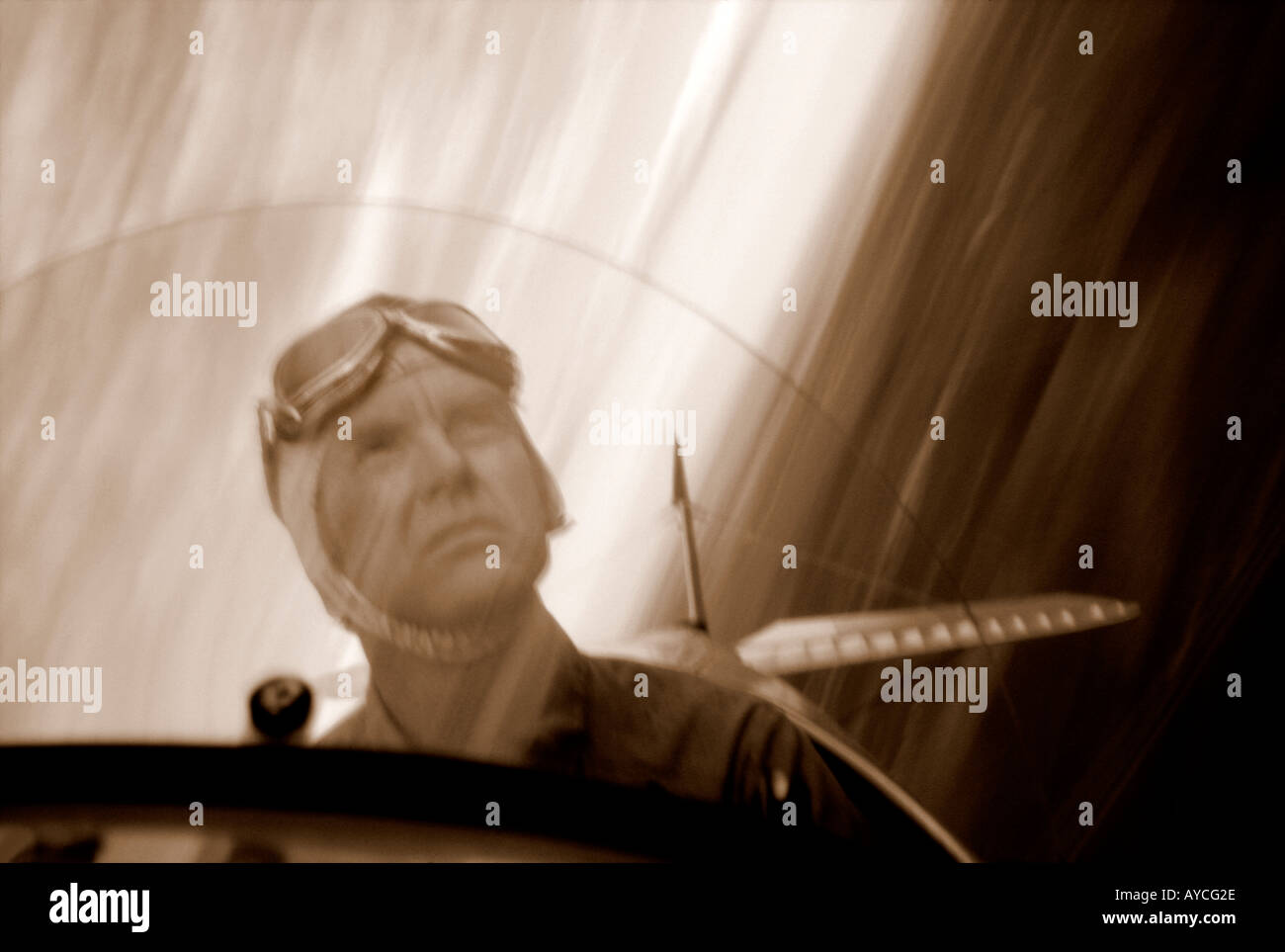 The pilot of an antique open cockpit biplane while inflight turning ...