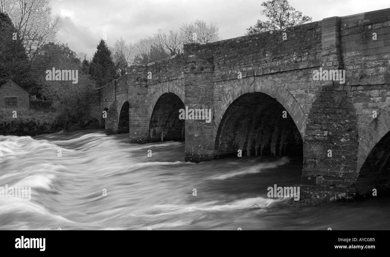 River water rushing under the arches of an old stone bridge Stock Photo ...