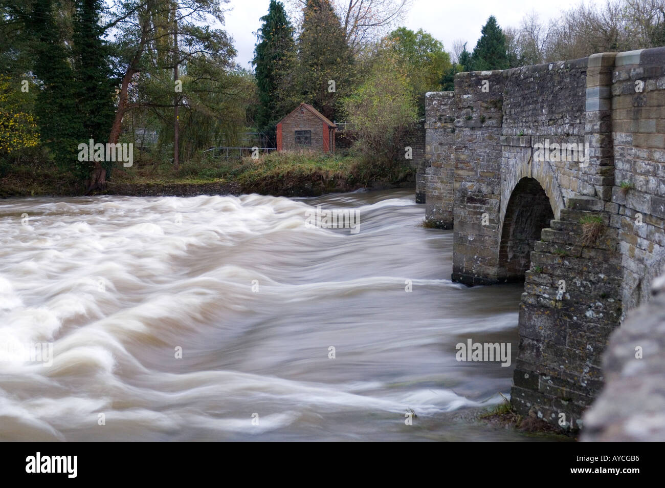 River water rushing under the arches of an old stone bridge Stock Photo ...