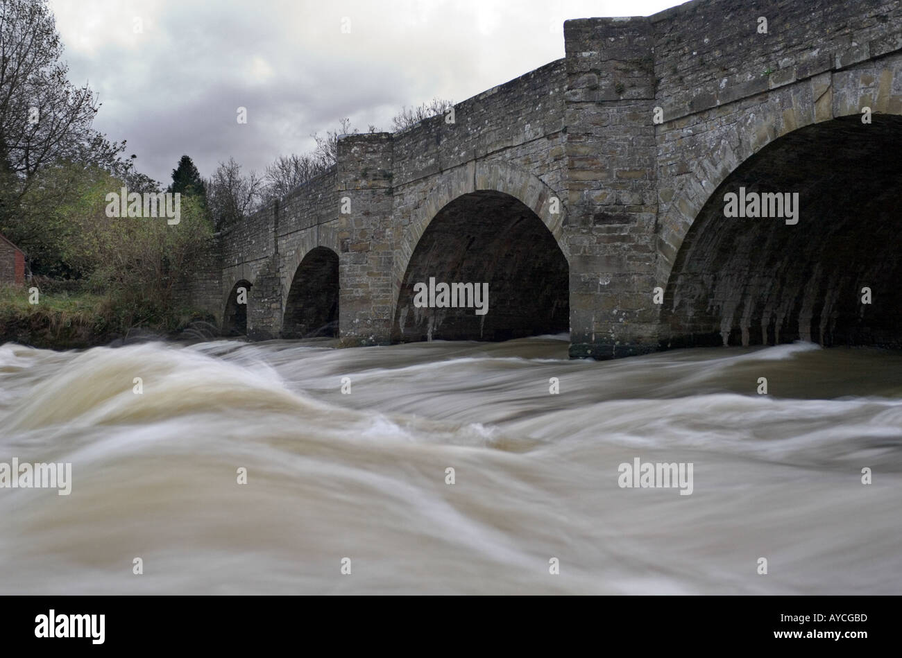 River water rushing under the arches of an old stone bridge Stock Photo ...
