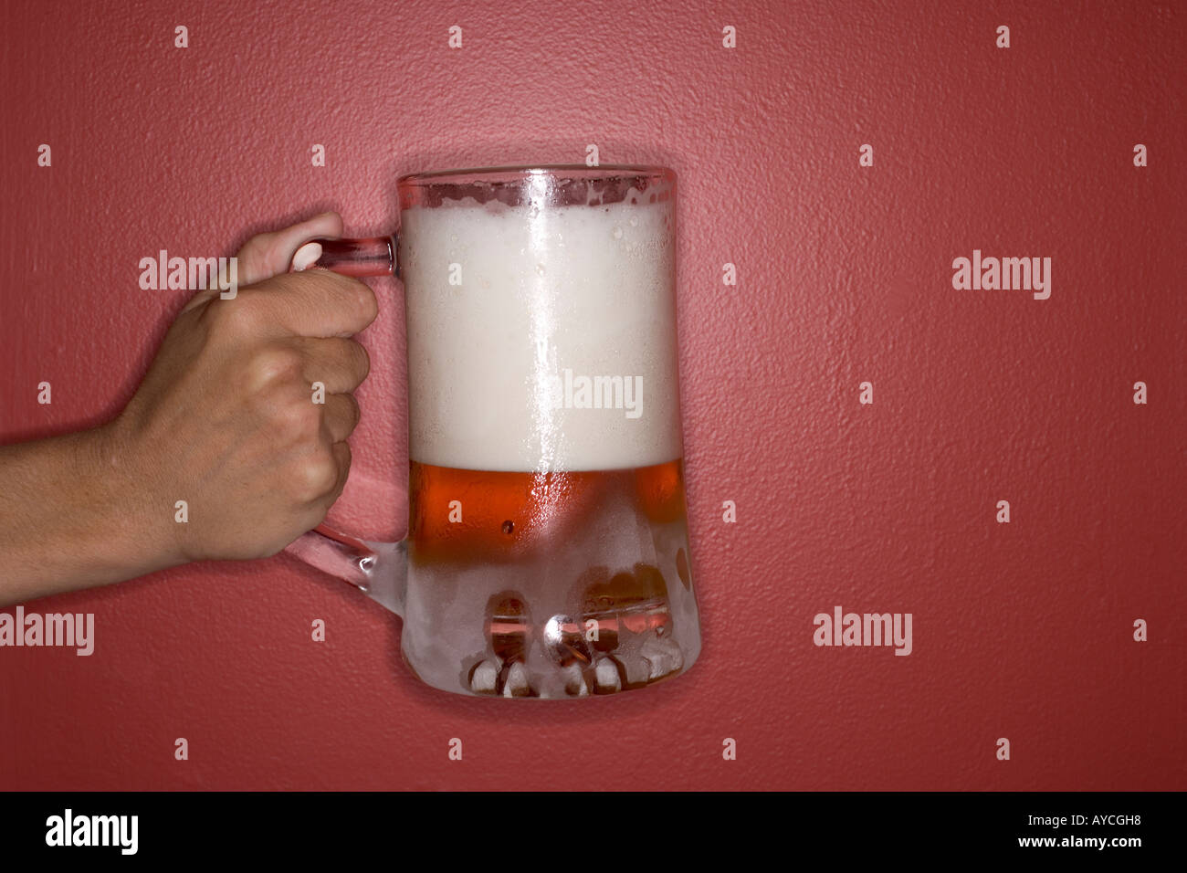Hand holding giant large mug of beer with red background Stock Photo ...