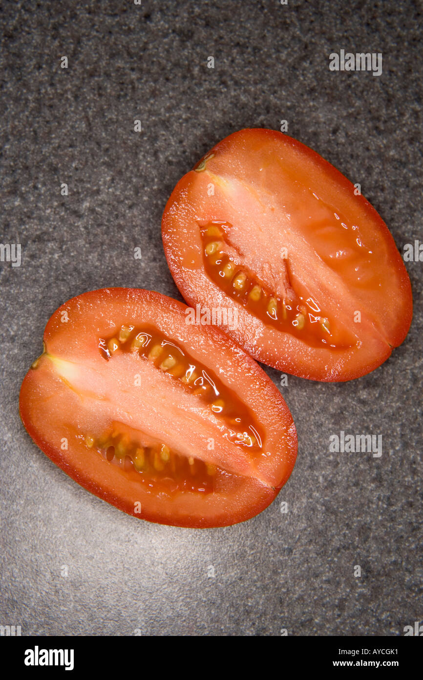 Two halves of a sliced tomato on cutting counter Stock Photo - Alamy