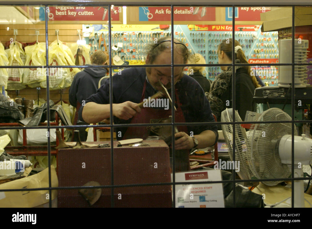 A cobbler at work in Oxfords covered market UK Stock Photo - Alamy