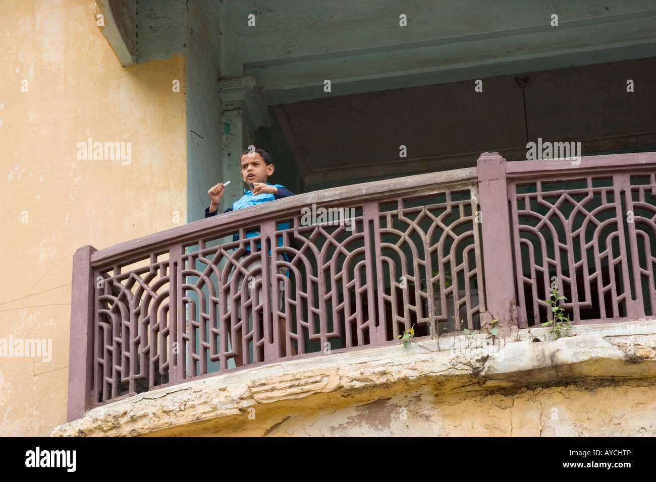 Small boy looking over the balcony of a house in Banaglore India Stock ...