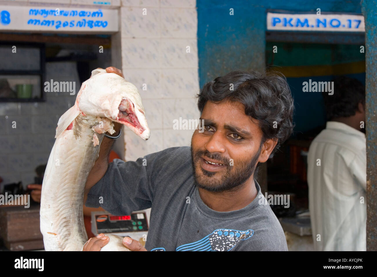 Indian fishmonger shows off his produce Stock Photo - Alamy