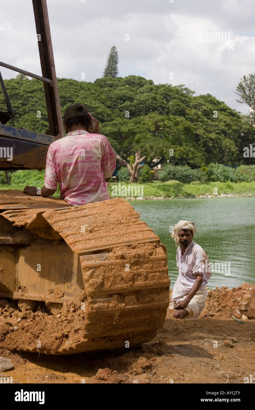 Digger and two builders on construction site in Bangalore India Stock ...