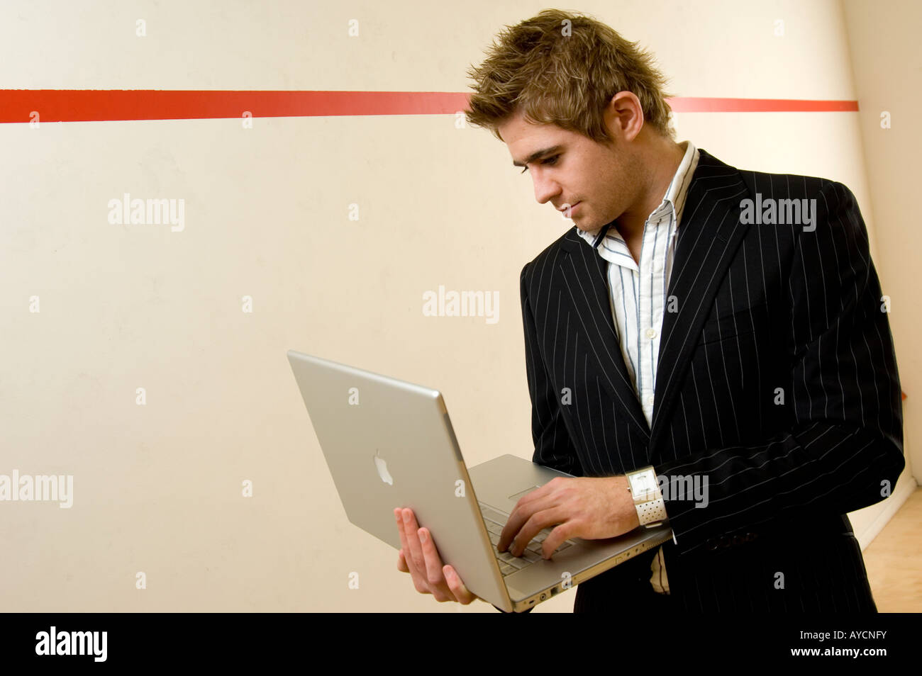 man standing using a laptop computer Stock Photo - Alamy