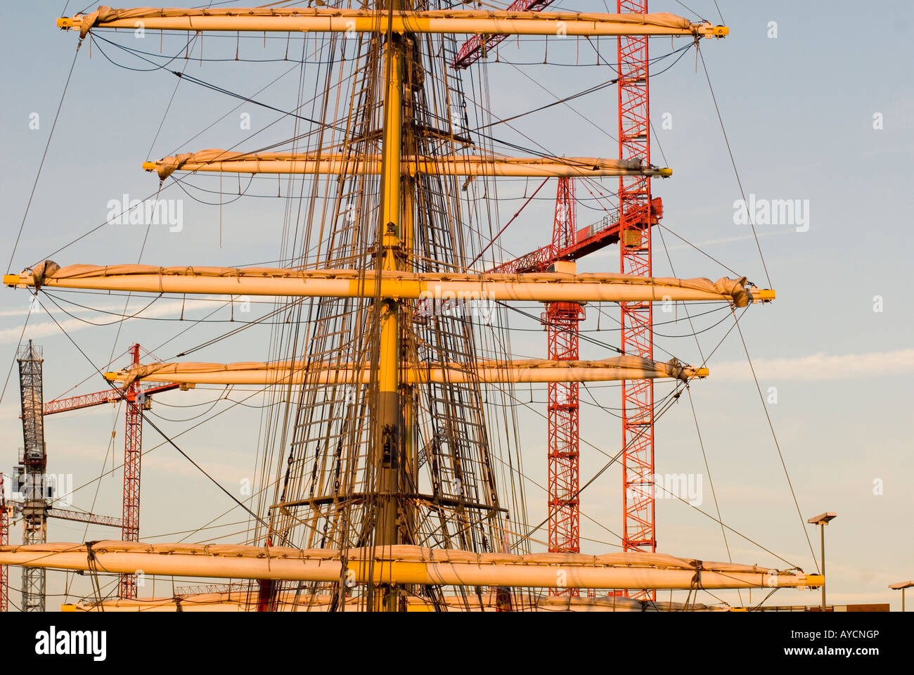 Mast of a tall ship in dock at Liverpool with tower cranes in ...