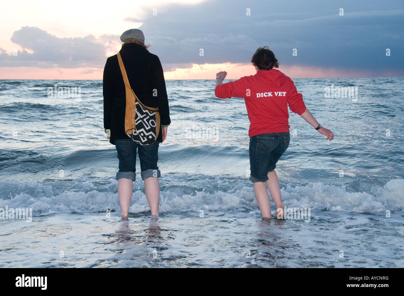 Two girls paddling in the sea at dusk students at Aberystwyth ...