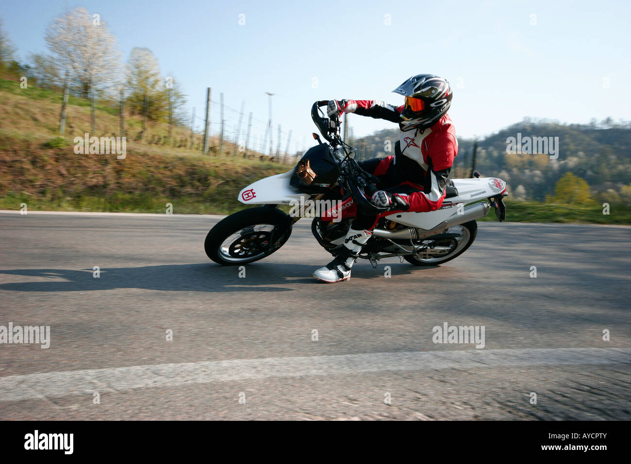 Biker is having fun riding his road bike in a corner of a hill's road ...
