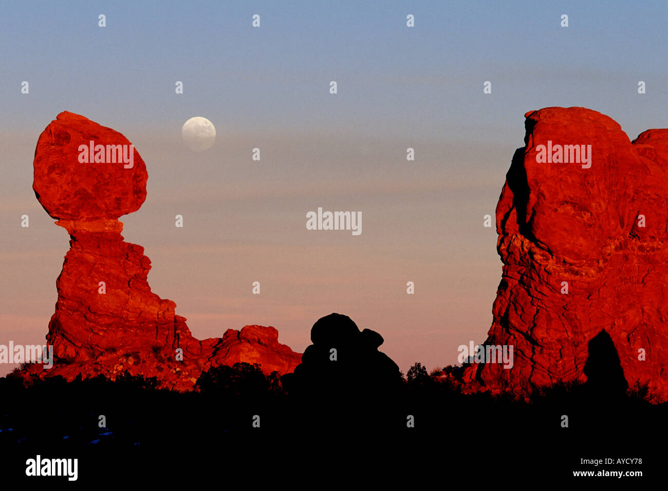 Full moon rising over balanced rock formation in late afternoon, Arches ...