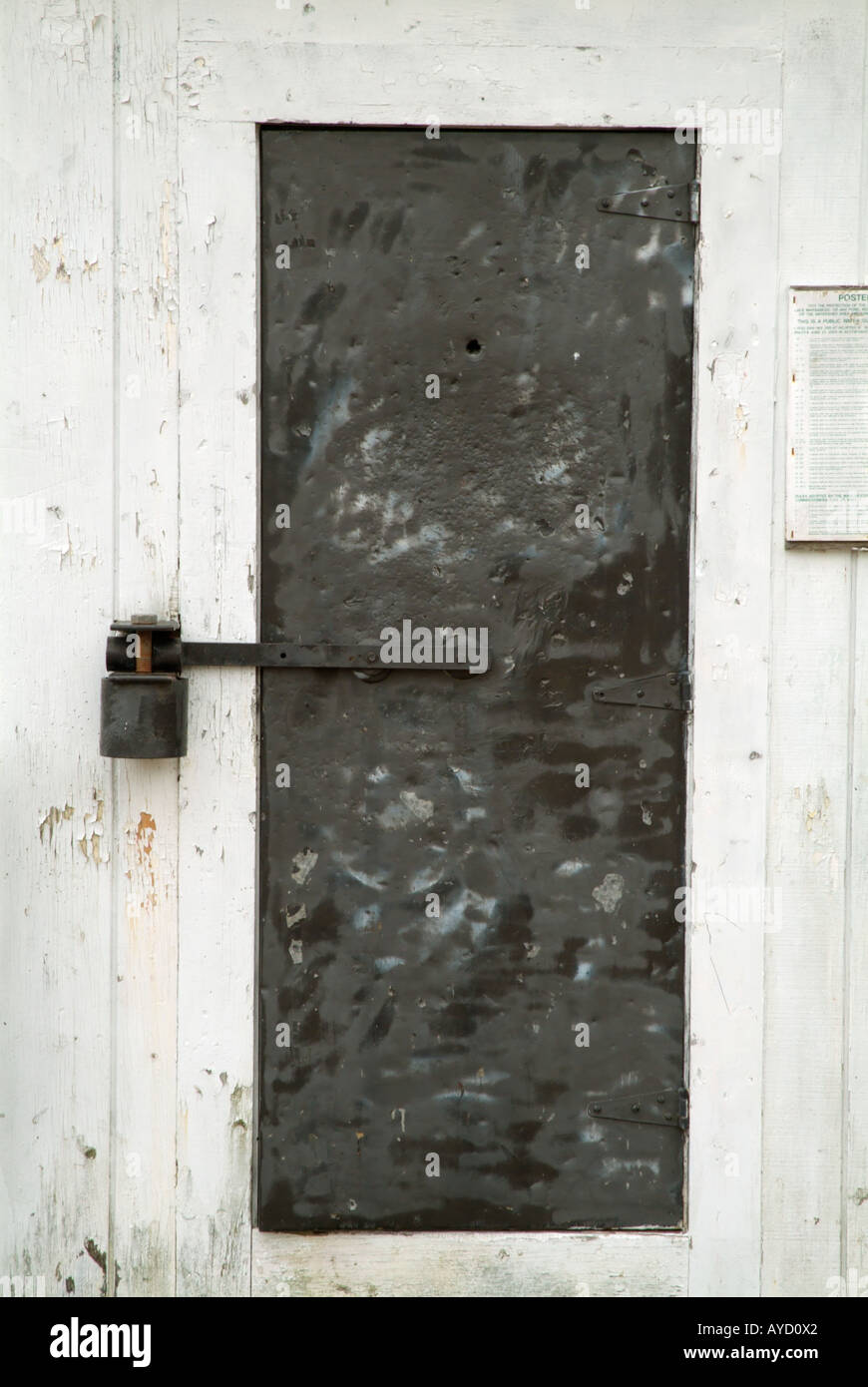 A black steel door attached to a building painted white Stock Photo - Alamy