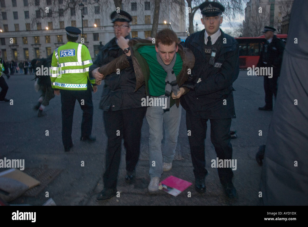 Police hold demonstrator's arms behind his back as the force him back ...