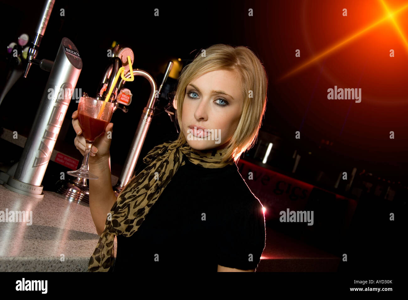 woman standing at a bar in a nightclub with a drink Stock Photo - Alamy
