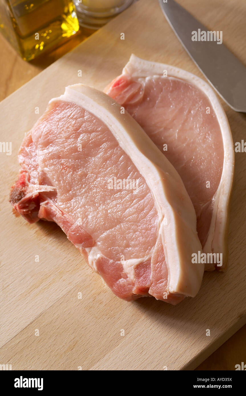 Two uncooked Pork Chops on chopping board Stock Photo - Alamy