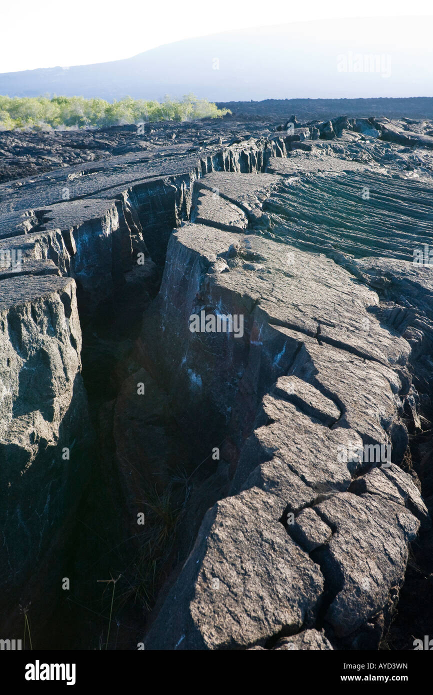 Extreme contrast with white sky and black lava with a deep fissure on ...