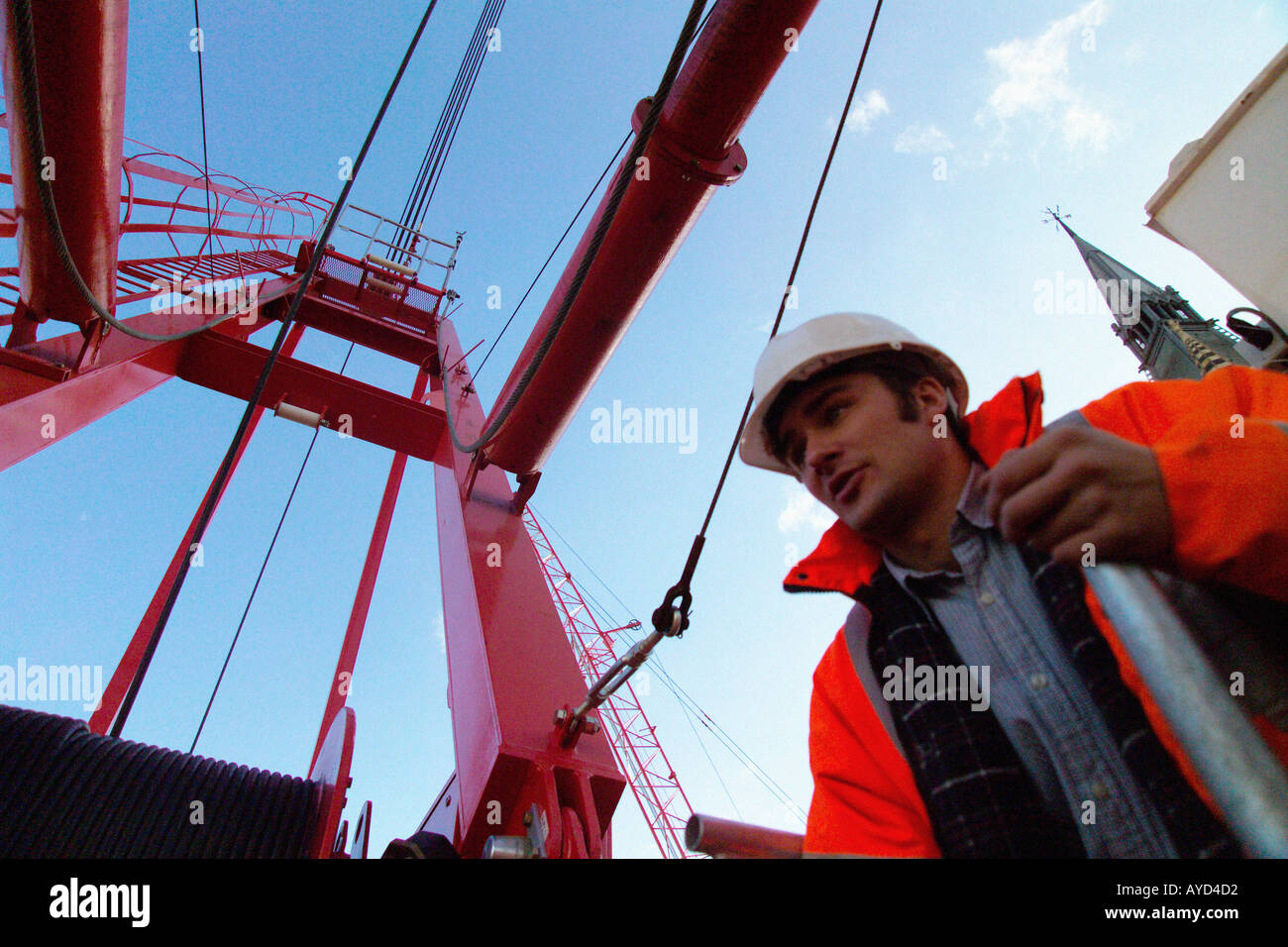 Construction worker by red crane Stock Photo - Alamy