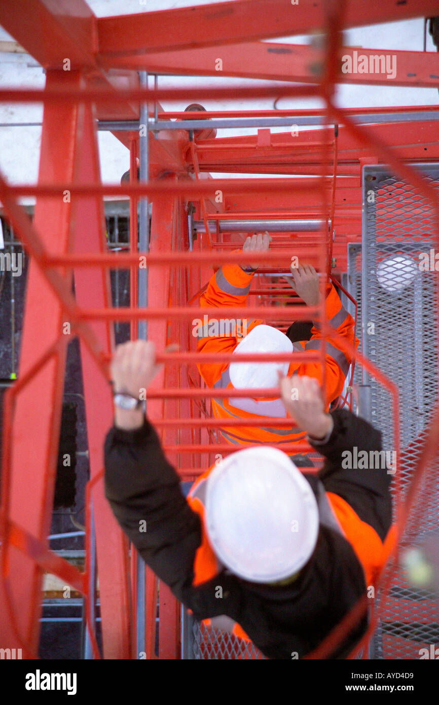 Construction workers climbing up a metal tower Stock Photo - Alamy