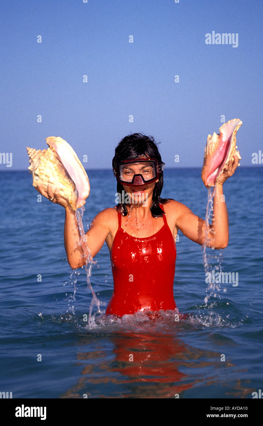 Caribbean woman holding two conch shells Stock Photo - Alamy