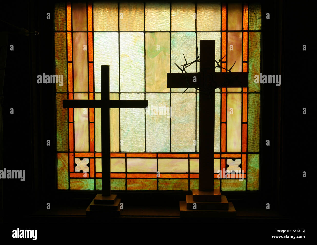 Two religious crosses sitting in a stained glass window sill of a ...