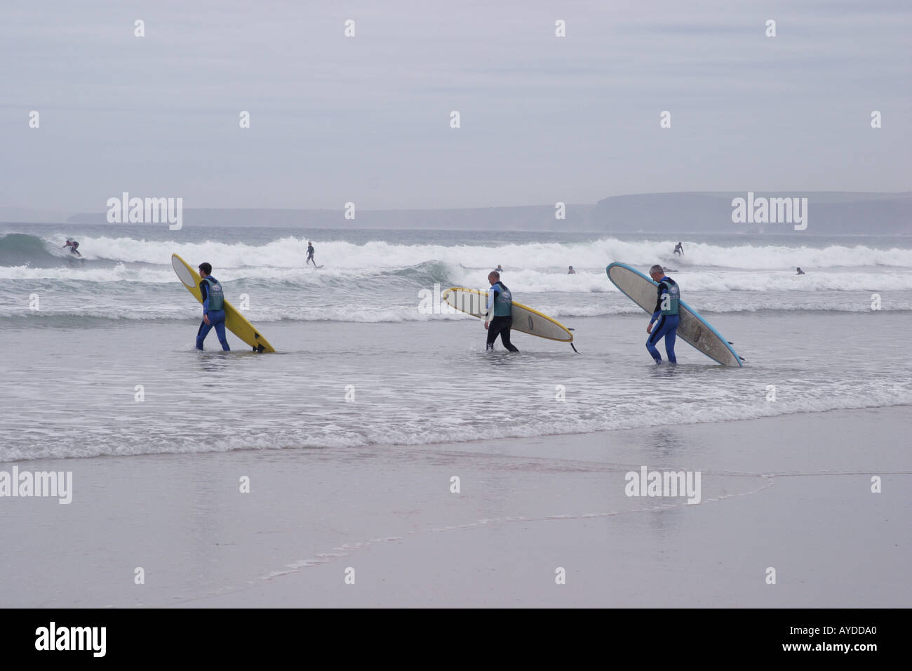 Three Surfers going out to sea in Newquay Devon Stock Photo - Alamy