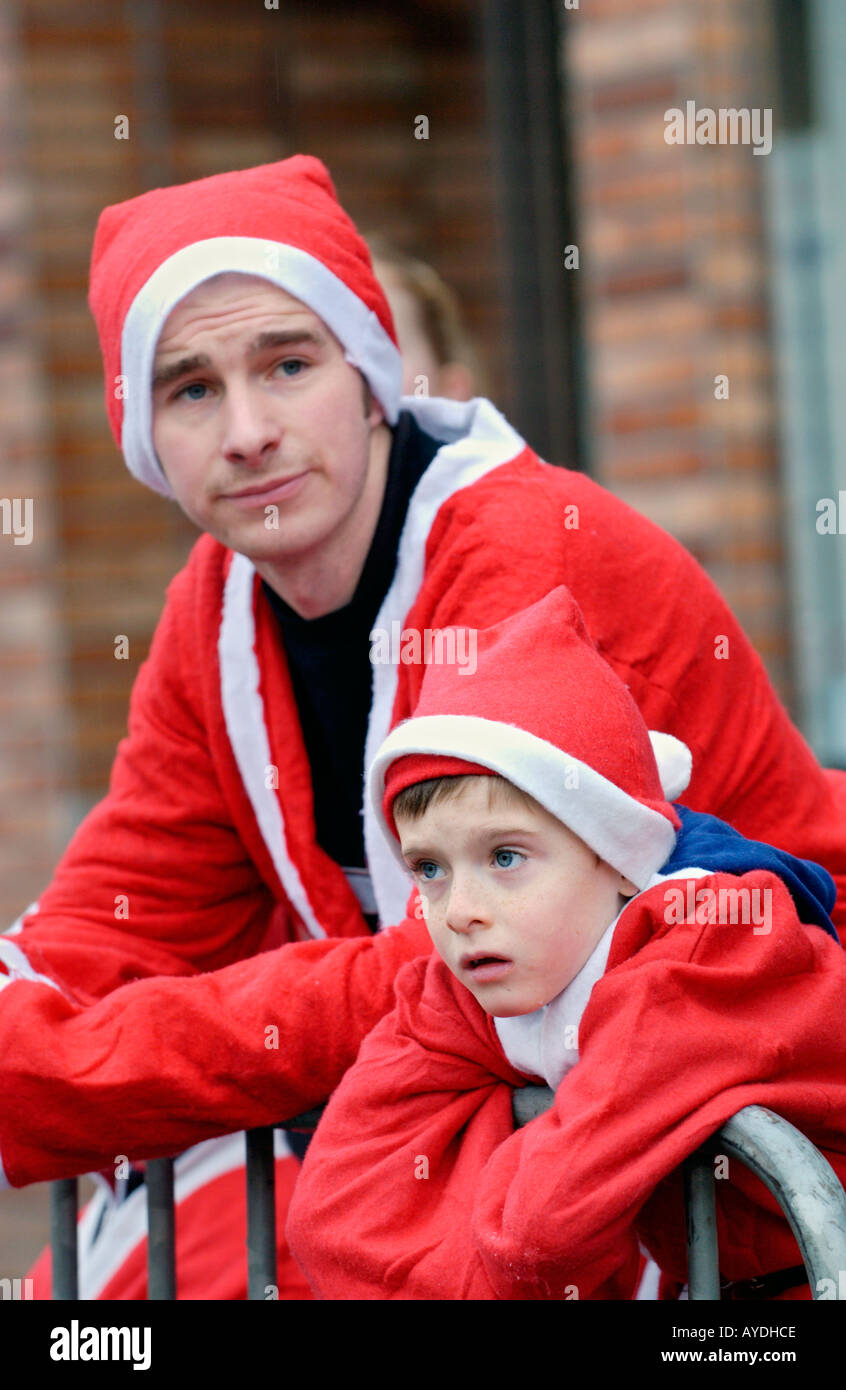Man and boy dressed as Santa Claus for the annual charity Santa Fun Run ...