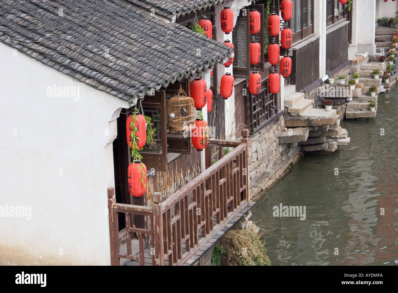 Chinese house with traditional red lanterns along a canal in Suzhou ...