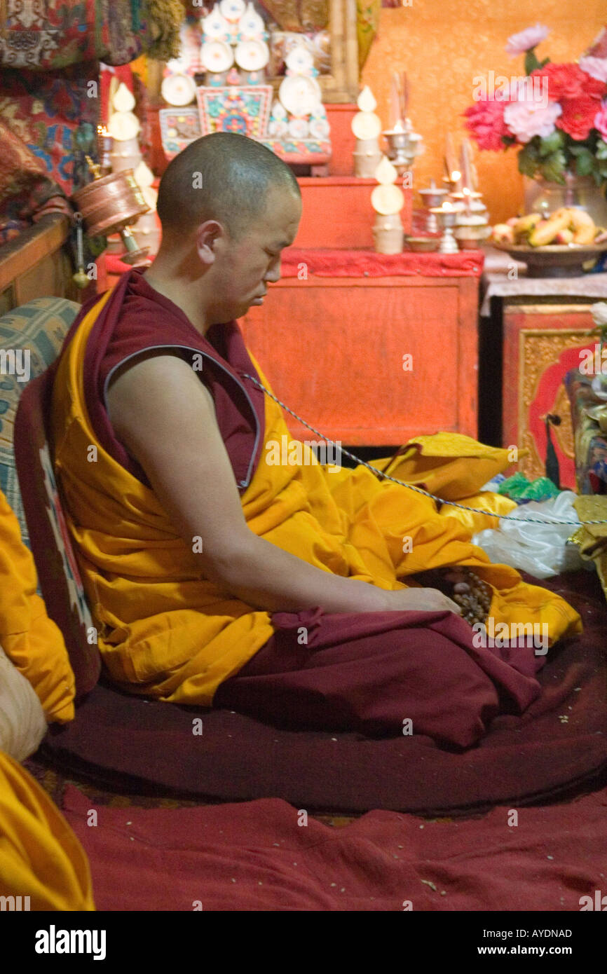 Tibetan monk deep in meditation in a small monastery located in Lhasa ...