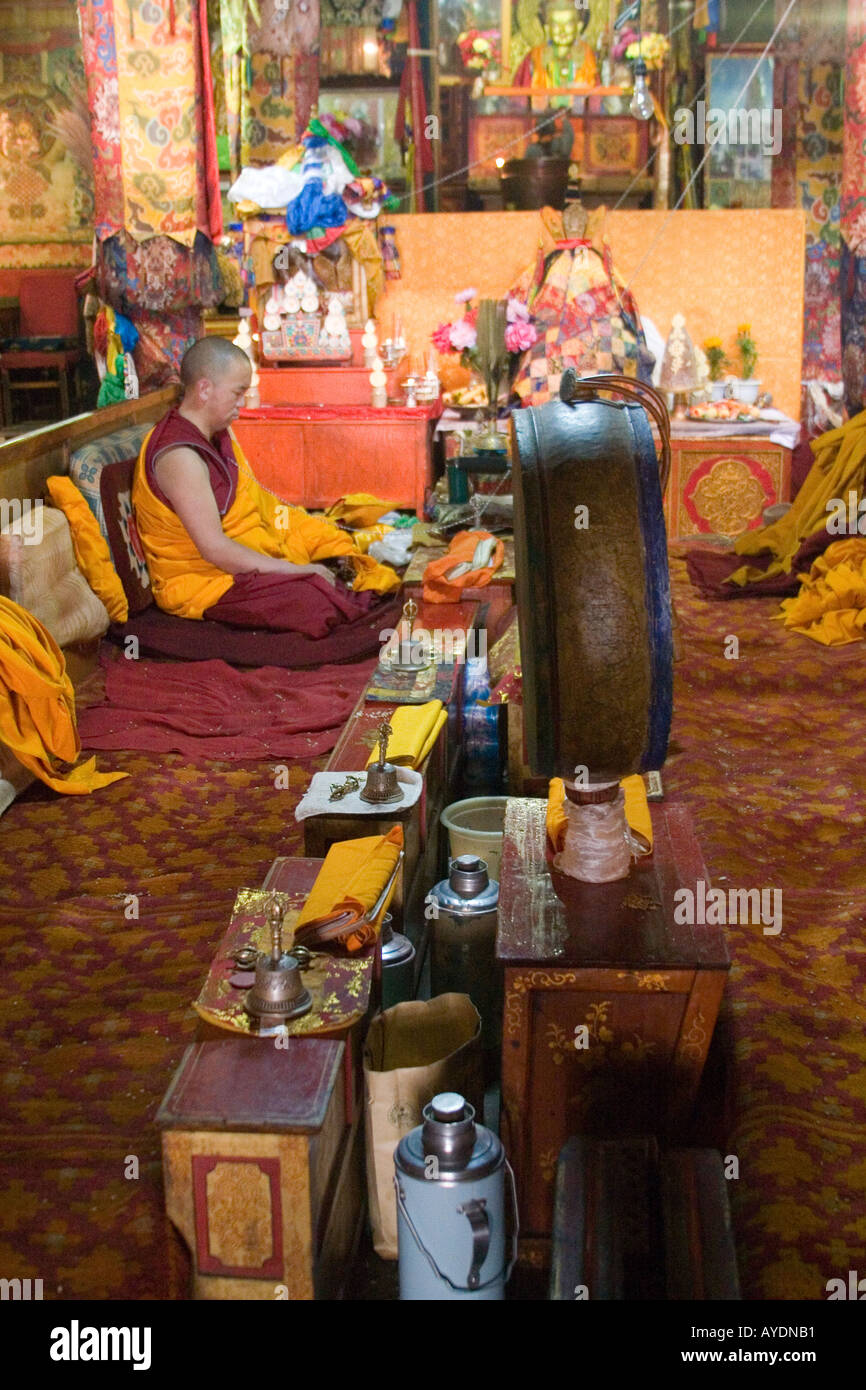 Lone tibetan monk meditating in a temple in a small monastary located ...