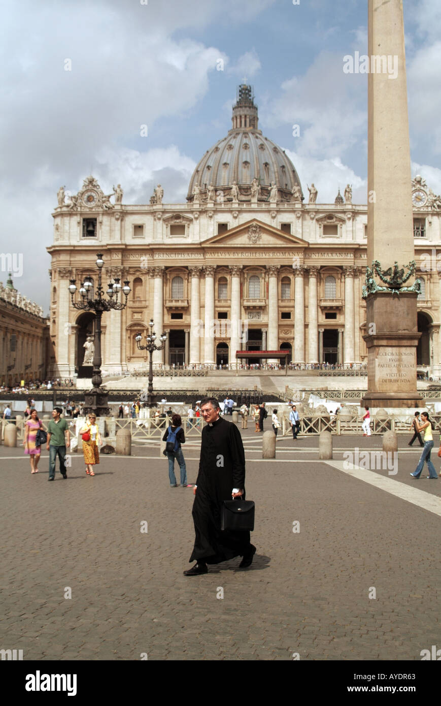 Priest wearing religious attire walking in St Peters Square backdrop of ...