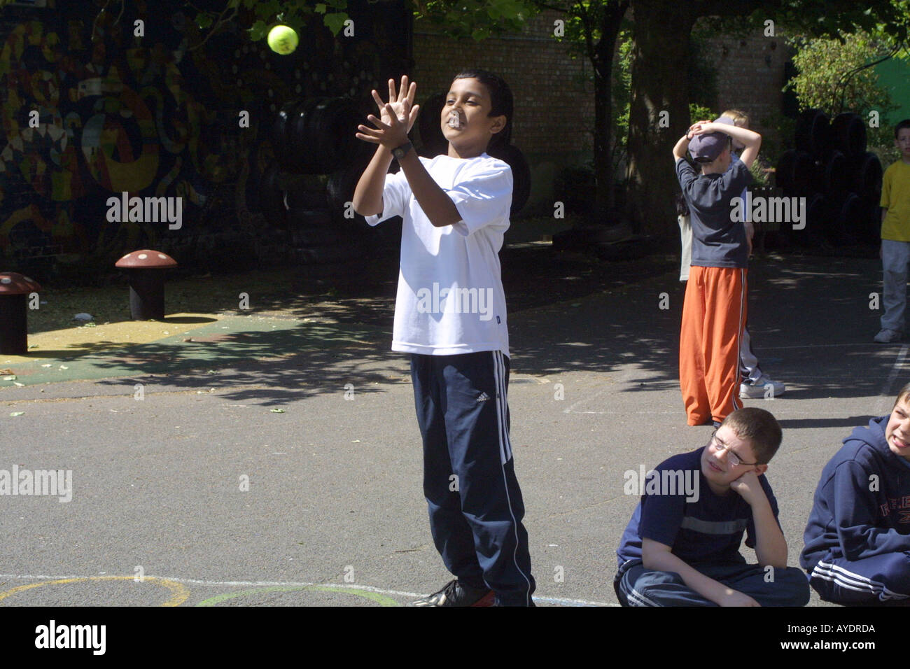 young boy catching a ball in primary school playground Stock Photo - Alamy