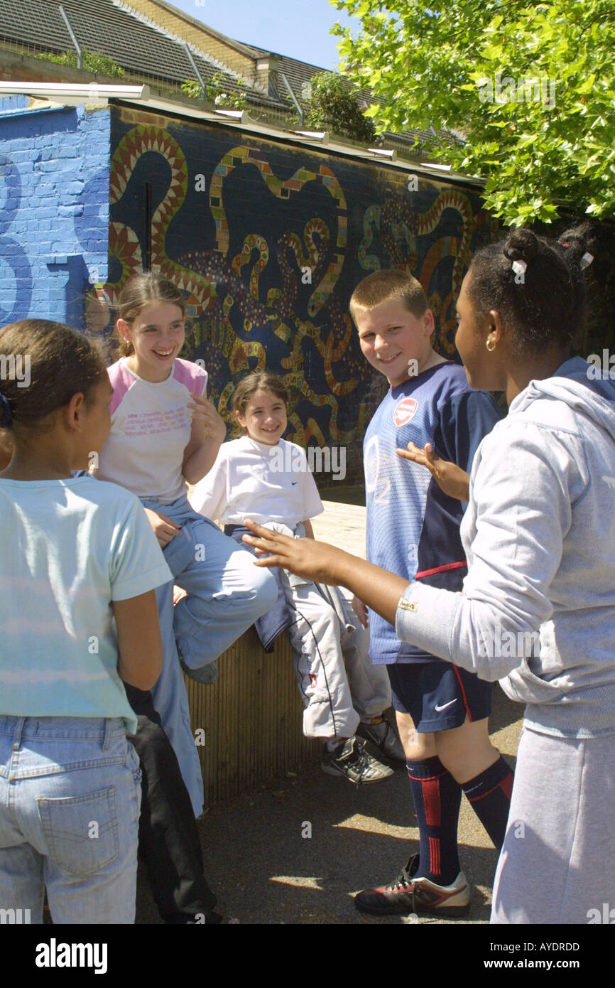 primary students in playground talking together Stock Photo - Alamy