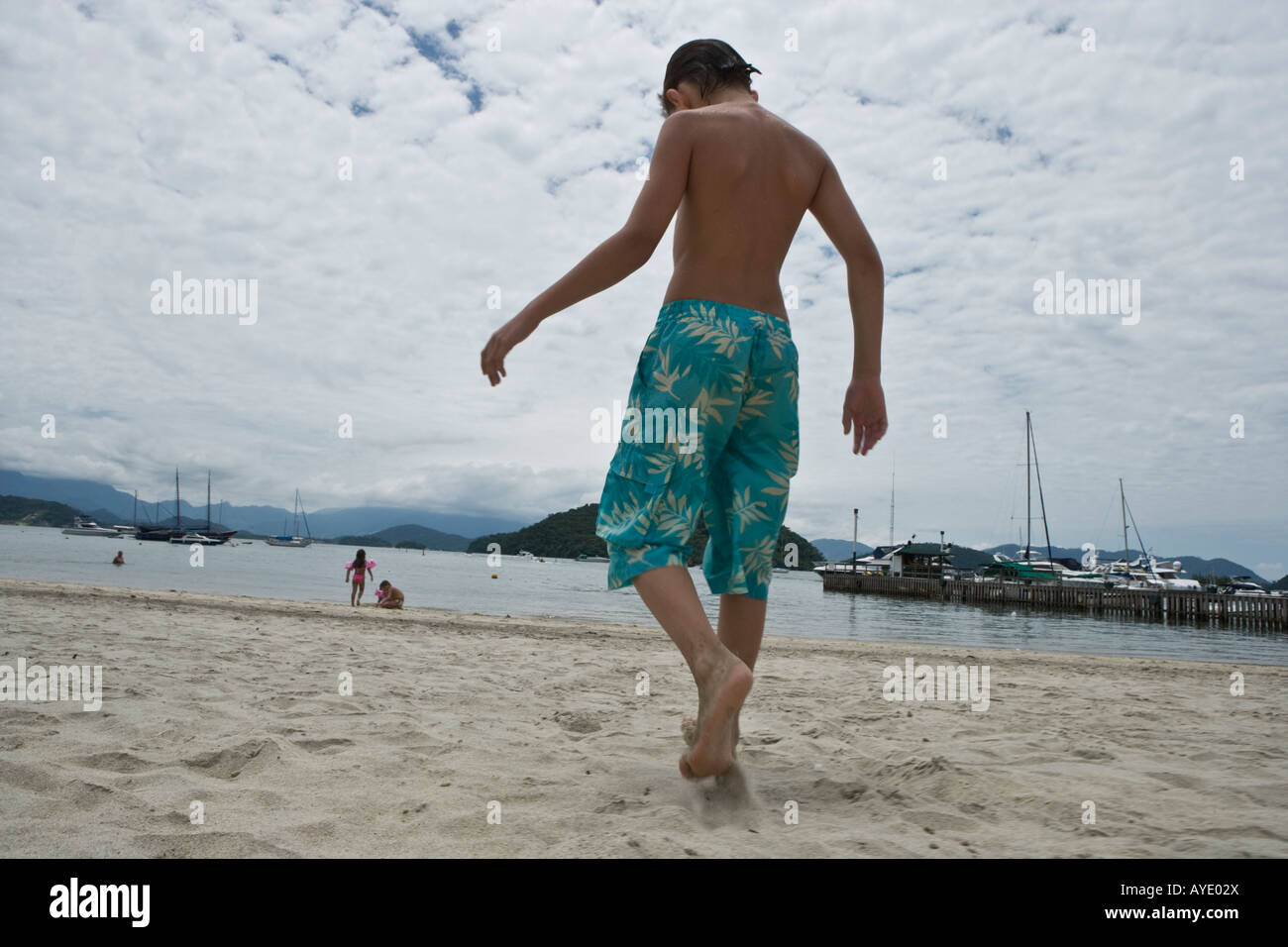 boy walking on the beach Stock Photo - Alamy