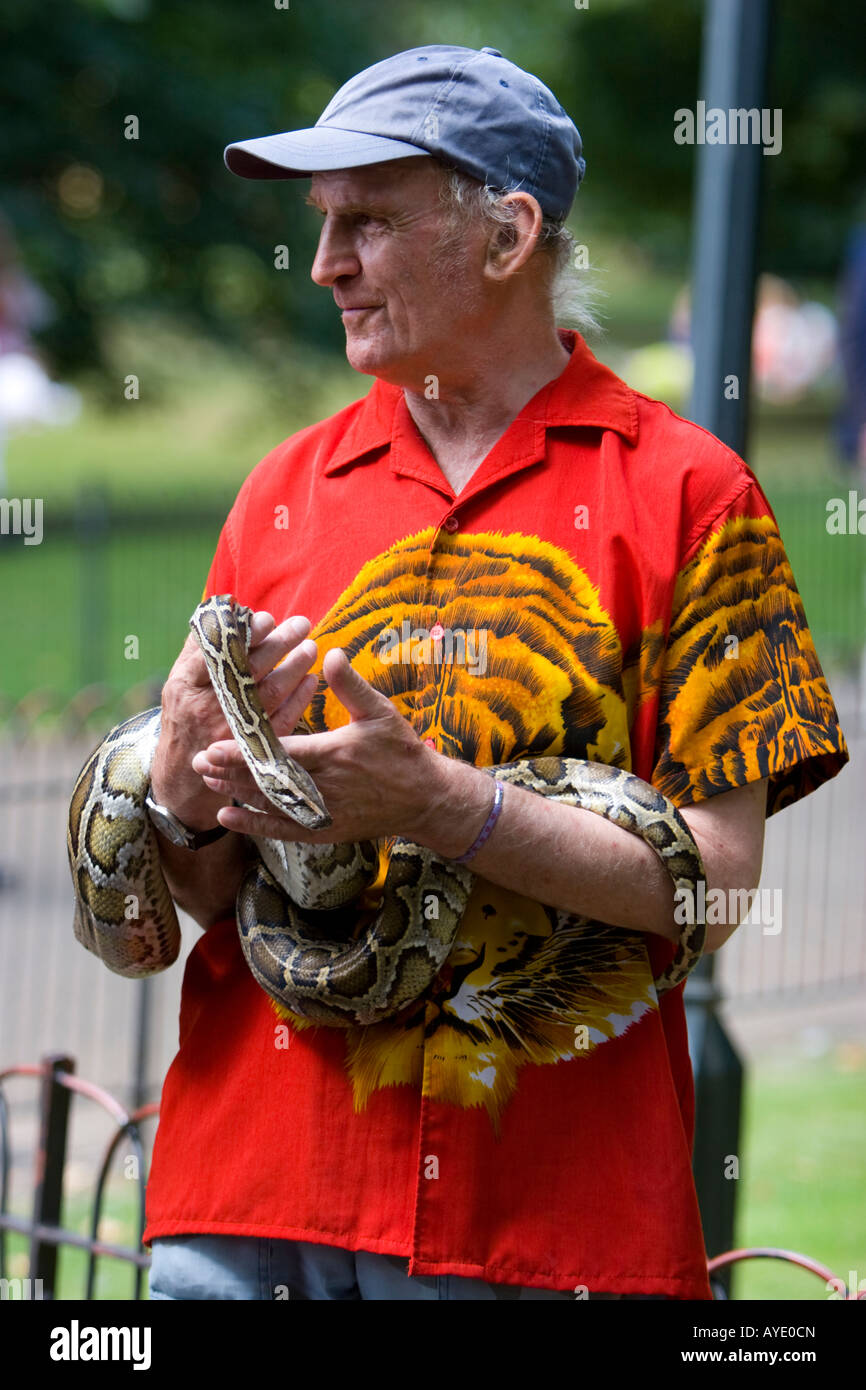 Gentleman with pet exotic snake taking it for a walk in a London park ...