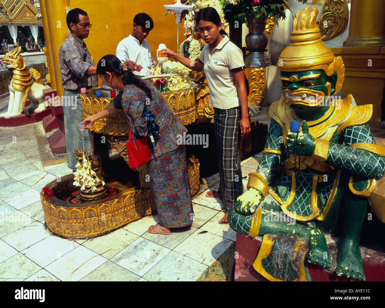 Myanmar Burma Yangon Rangon Shwedagon budhist shrine people watering a ...