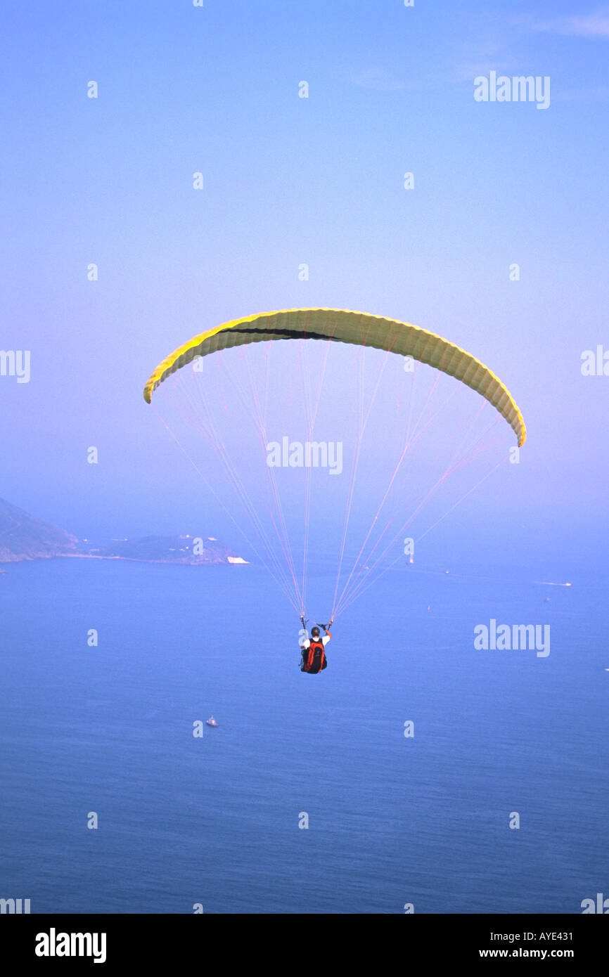 A paraglider soars above the ocean at the Shek O peninsula in Hong Kong ...