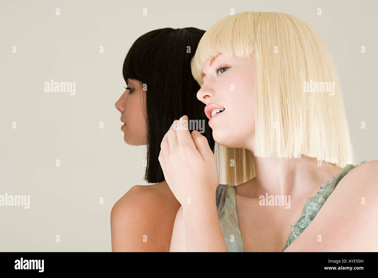Young women whispering Stock Photo - Alamy