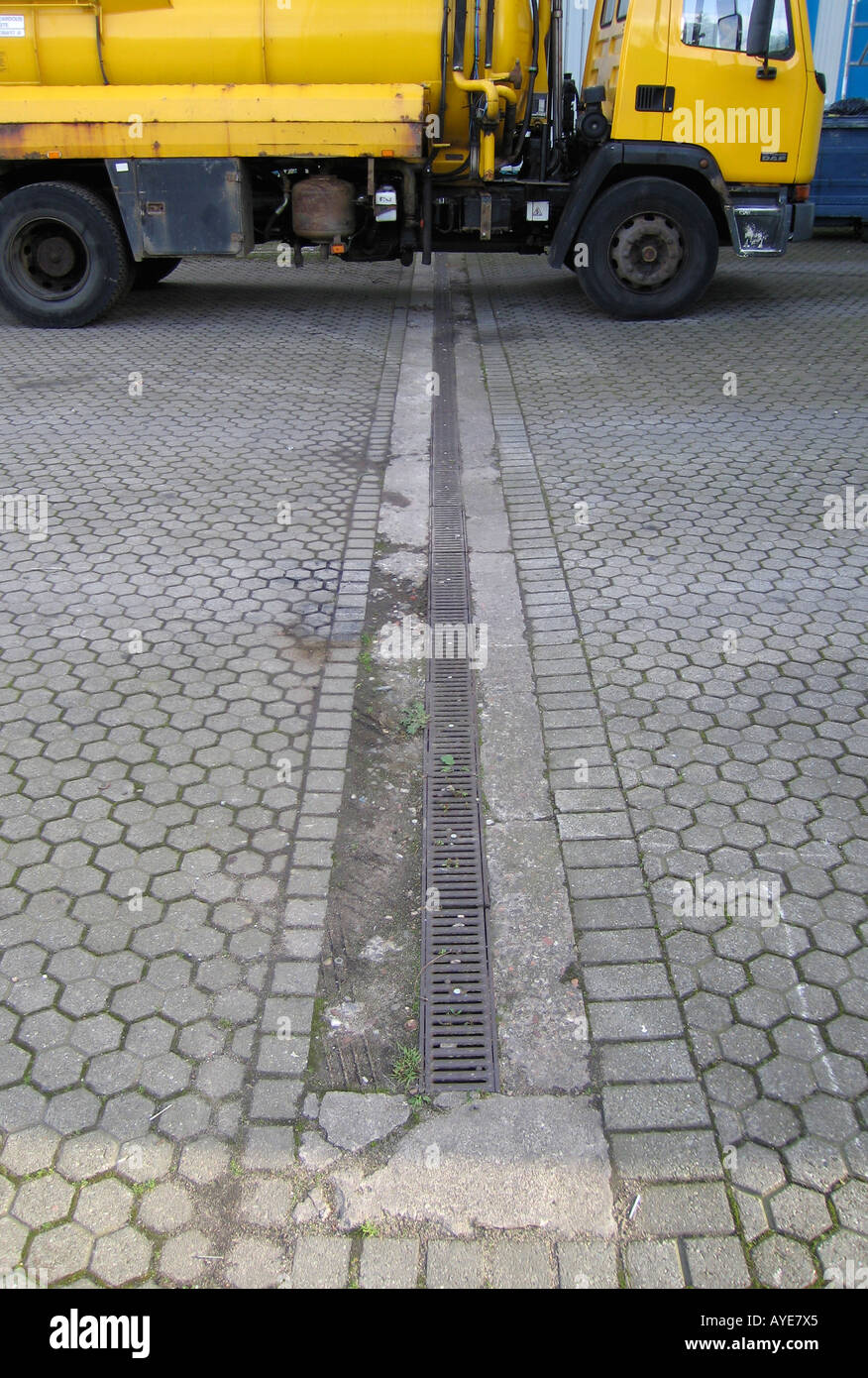 Drainage pumping vehicle astride road drain gully Stock Photo - Alamy