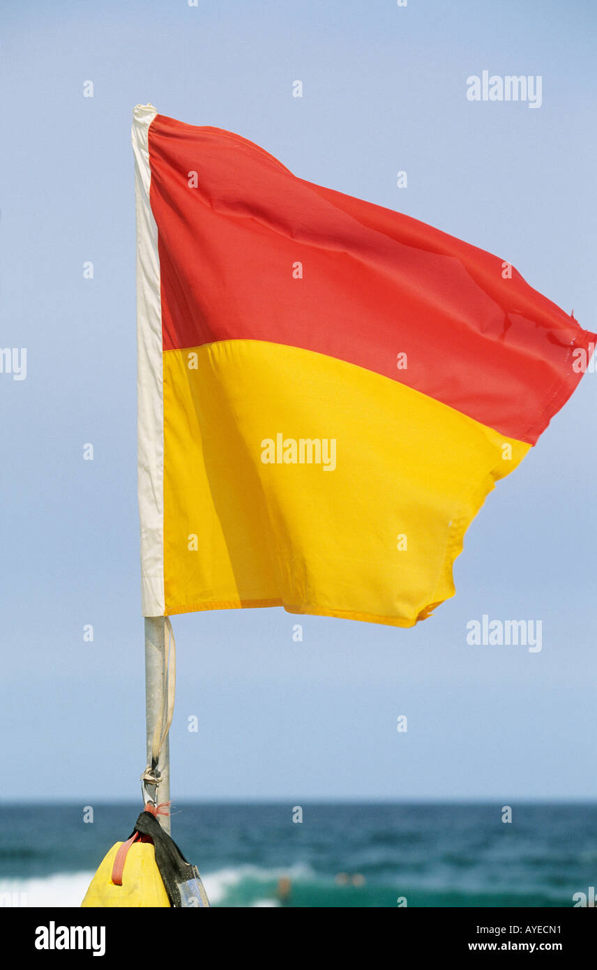 Detail of Red and yellow Surf life saving flag against a blue sky ...