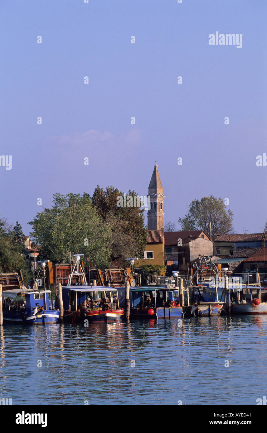 fishing boats moored on the island of burano with the leaning ...
