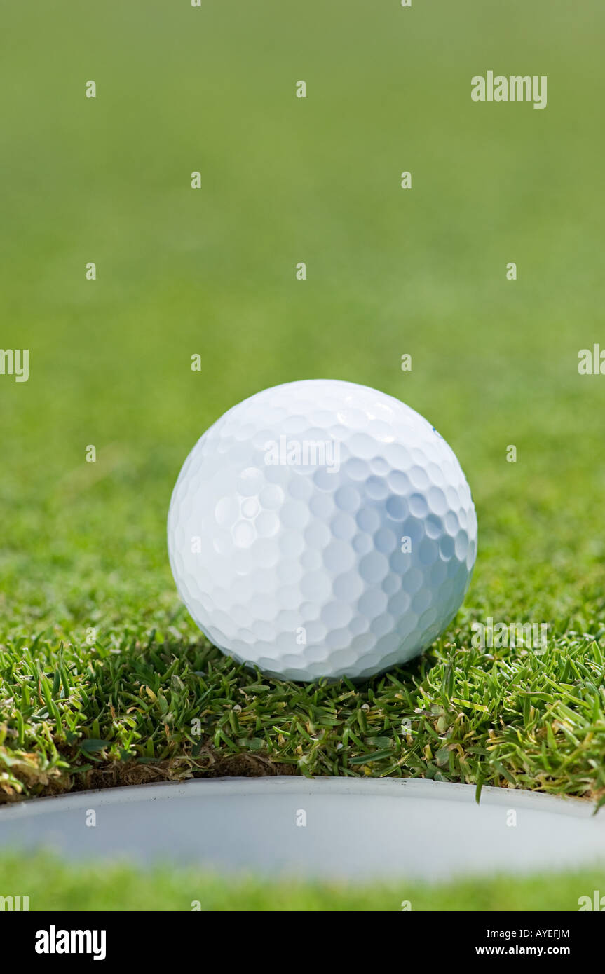 A golf ball and hole Stock Photo - Alamy