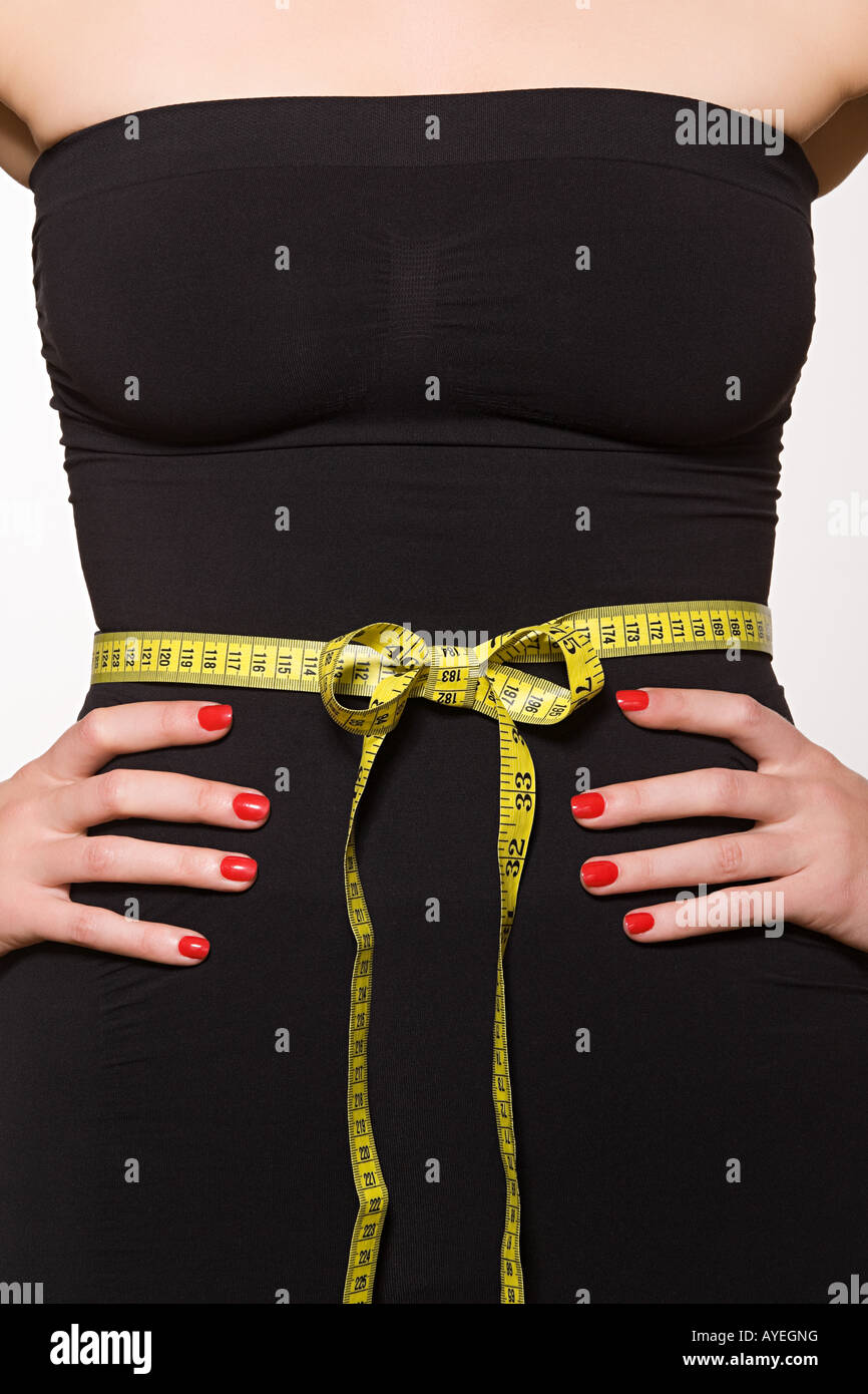 Woman with tape measure around her waist Stock Photo - Alamy