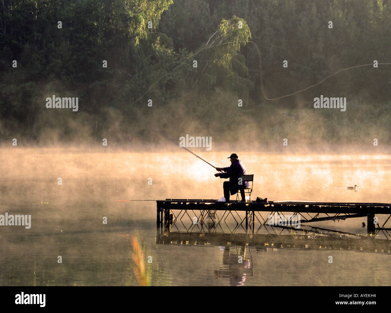 Fisherman on lake Stock Photo - Alamy